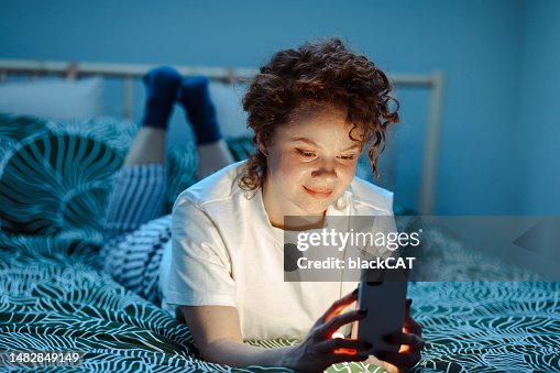 Femme En Pyjama Utilisant Un Téléphone Intelligent Au Lit La Nuit Photo