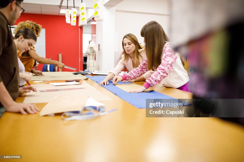 Woman Teaching Her Students How To Trace Clothing Pattern On Fabric ... Woman Teaching Her Students How To Trace Clothing Pattern On Fabric ...