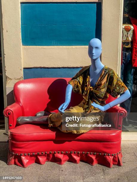 Blue mannequin sitting on red couch 이미지 (1491247103) - 게티이미지뱅크