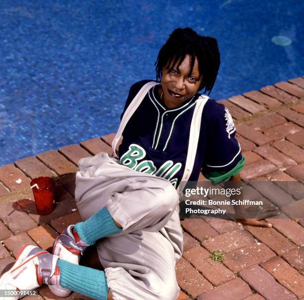 American Actress Whoopi Goldberg Poses For A Portrait Sitting Next To