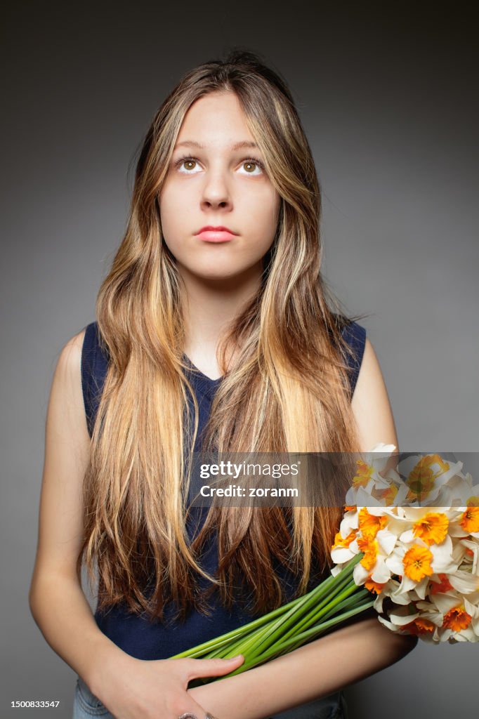 Teenage Girl With Long Naturally Blond Hair Looking Up And Holding