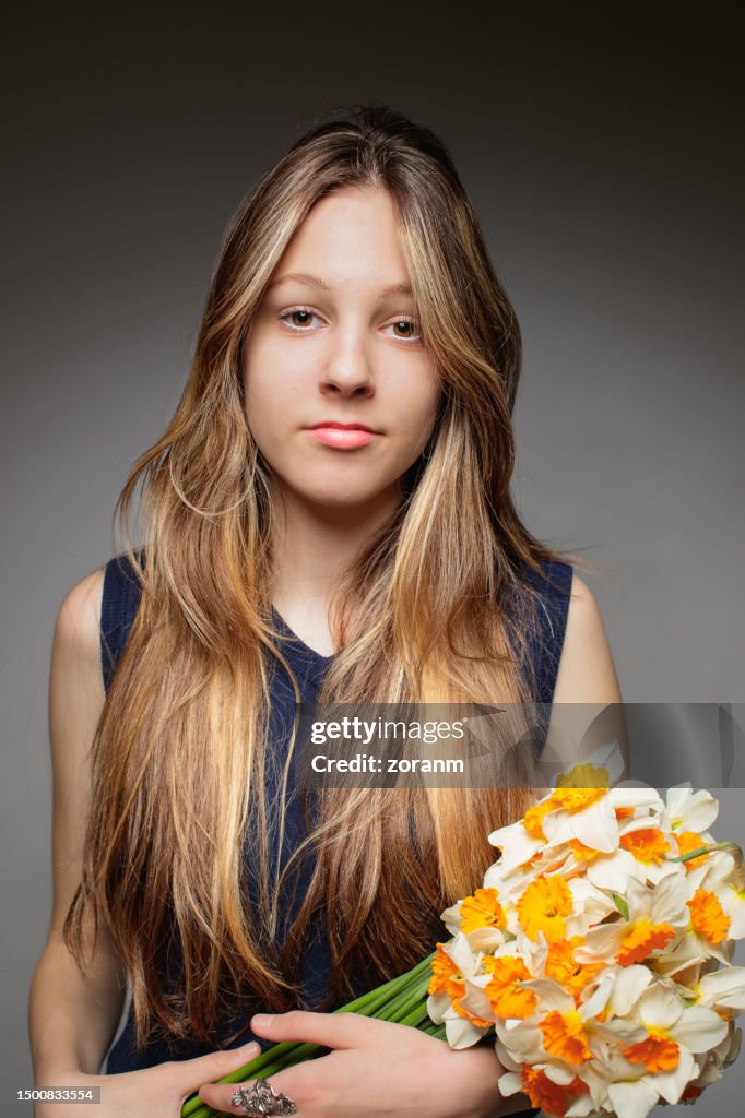 Teenage Girl With Long Naturally Blond Hair Holding A Bunch Of