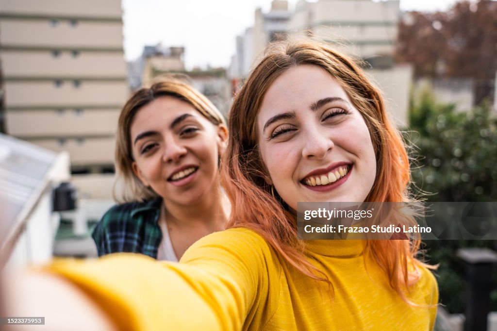 Young Lesbian Couple Taking A Selfie Outdoors Camera Point Of View High