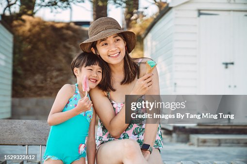 Mom Daughter Eating Ice Cream Joyfully In Front Of The Beach Huts At