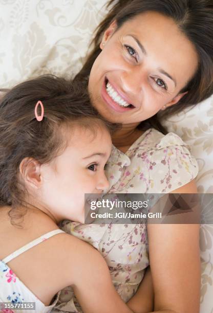 60 Overhead View Smiling Mother And Daughter Hugging On Bed Stock