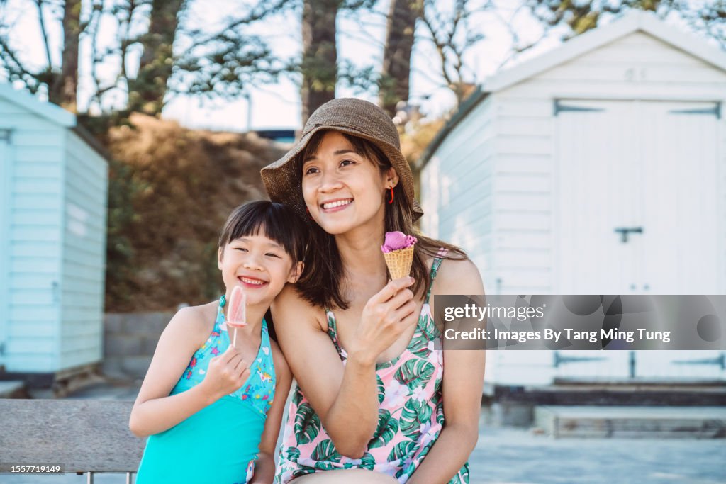 Mom Daughter Eating Ice Cream Joyfully In Front Of The Beach Huts At