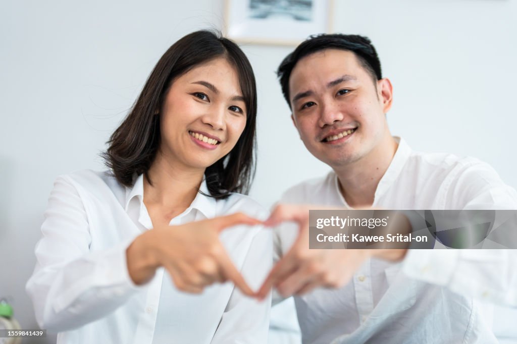 Portrait Of Asian New Marriage Couple Sit On Bed And Looking At Camera Attractive Beautiful
