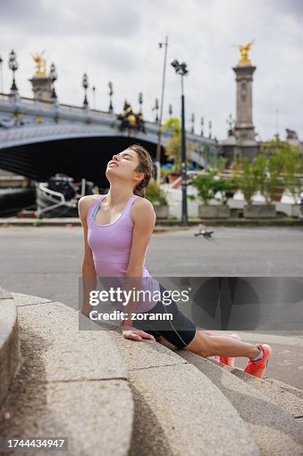 Jeune Femme Sétirant Sur Les Escaliers En Béton Au Bord De Leau De La