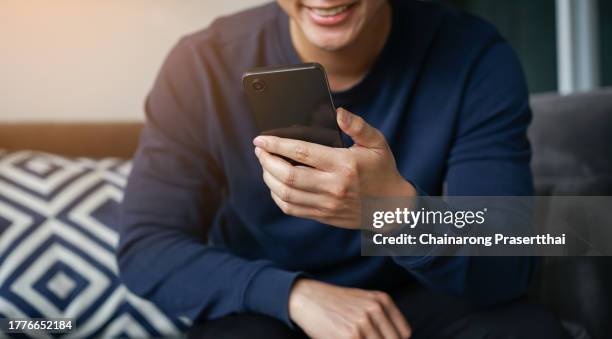 Close up asian man using smart phone mobile device for play or shopping ...
