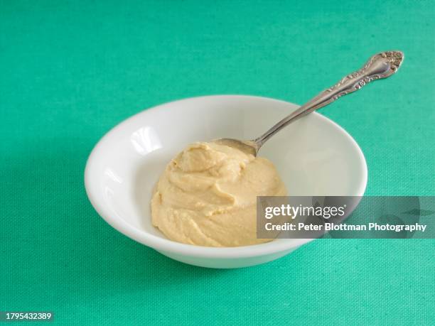 Fresh hummus serving in white bowl with spoon 이미지 (1795432389) - 게티이미지뱅크