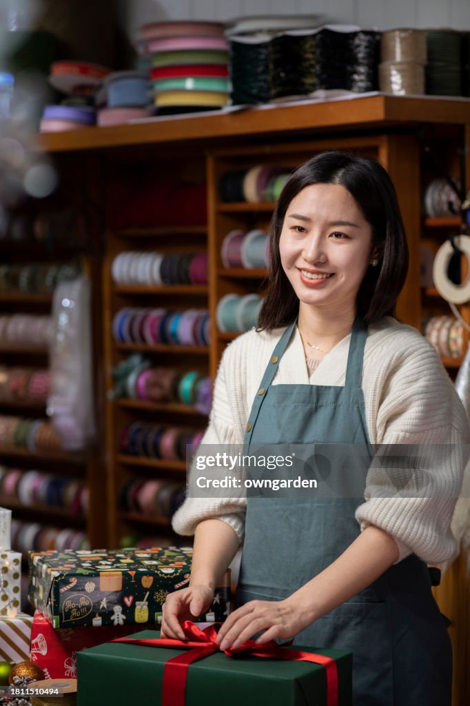Asian Female Shop Assistant Wrapping The Christmas Presents In Christmas Shop High Res Stock