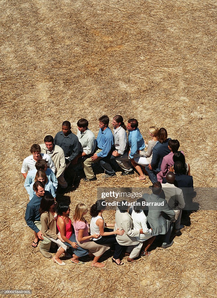 Group Of People Sitting On Each Others Laps Forming Circle Stock Foto