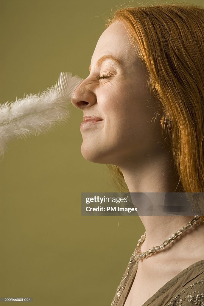 Young Woman With Nose Being Tickled By Feather Profile High Res Stock