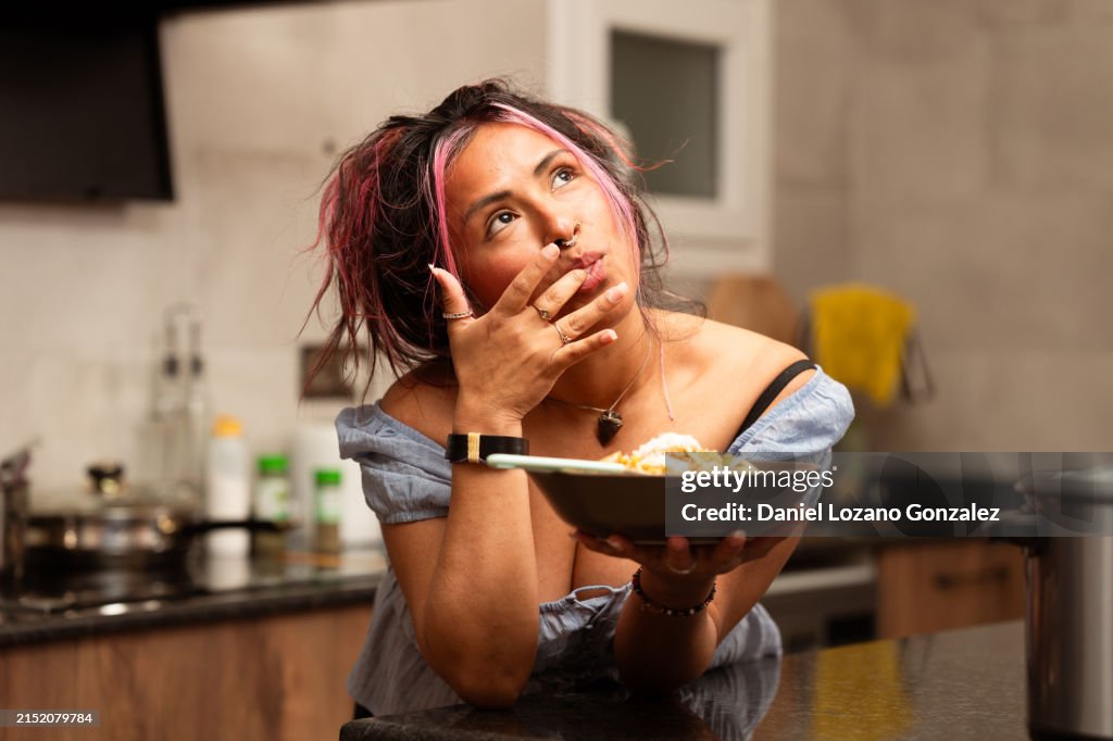 Woman Licking Her Fingers While Enjoying A Homemade Plate Of Pasta High