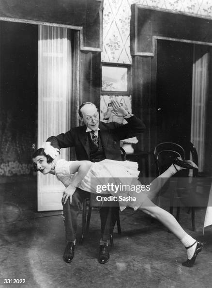 A Man Puts A Woman Across His Knee And Spanks Her In A Scene From