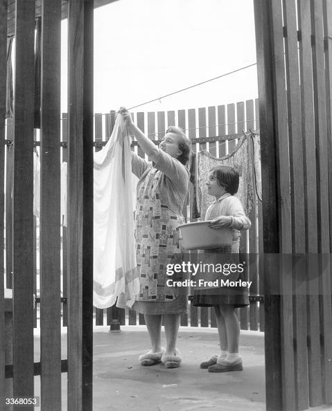 Mrs Clemos Nine Year Old Daughter Helps Her To Hang Out The Washing