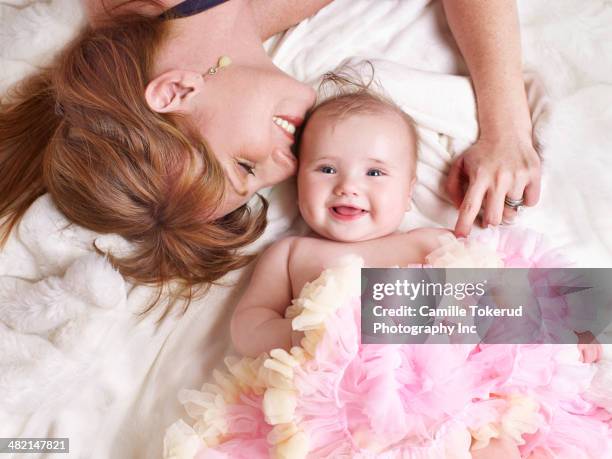 61 Overhead View Smiling Mother And Daughter Hugging On Bed Stock
