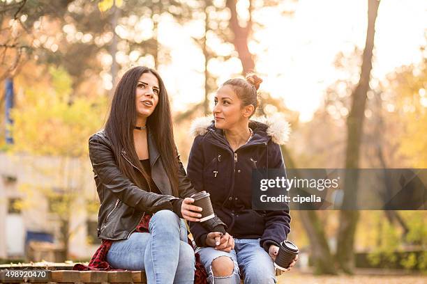 Romantic Lesbian Couple Sitting On Park Bench Photos And Premium High