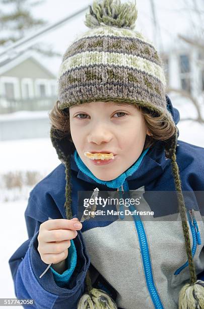 Young boy eating maple syrup taffy outside 이미지 (517742058) - 게티이미지뱅크