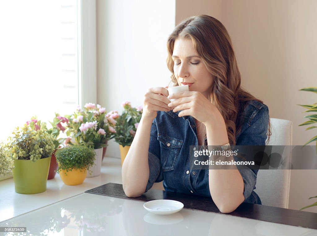 Young Beautiful Woman Sitting At The Table Drinking Coffee High Res