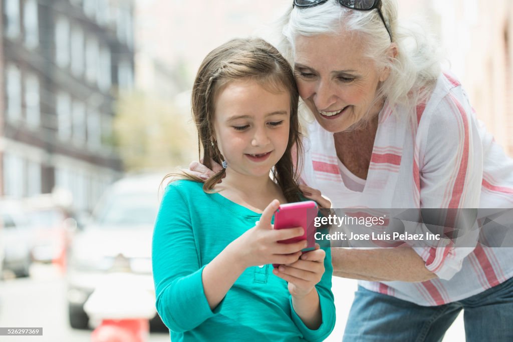 Caucasian Grandmother And Granddaughter Using Cell Phone High Res Stock