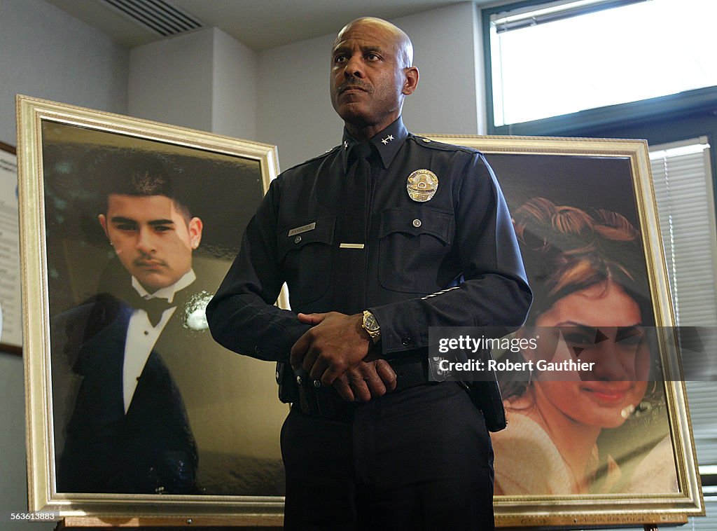 Lapd Deputy Chief Earl Paysinger Standing In Front Of Pictures Of