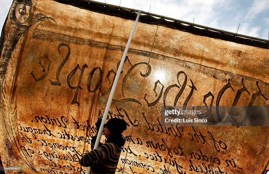 Protester Raymond Castaneda hoists a banner with the preamble to the ... Protester Raymond Castaneda hoists a banner with the preamble to the ...