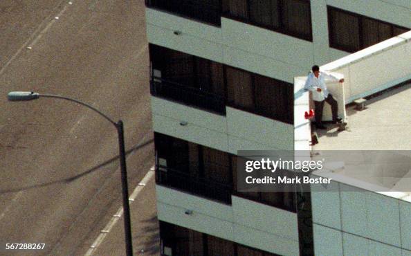 Me Gunman Rooftop 012797 Mb A Man With A Gun Perched Himself On A