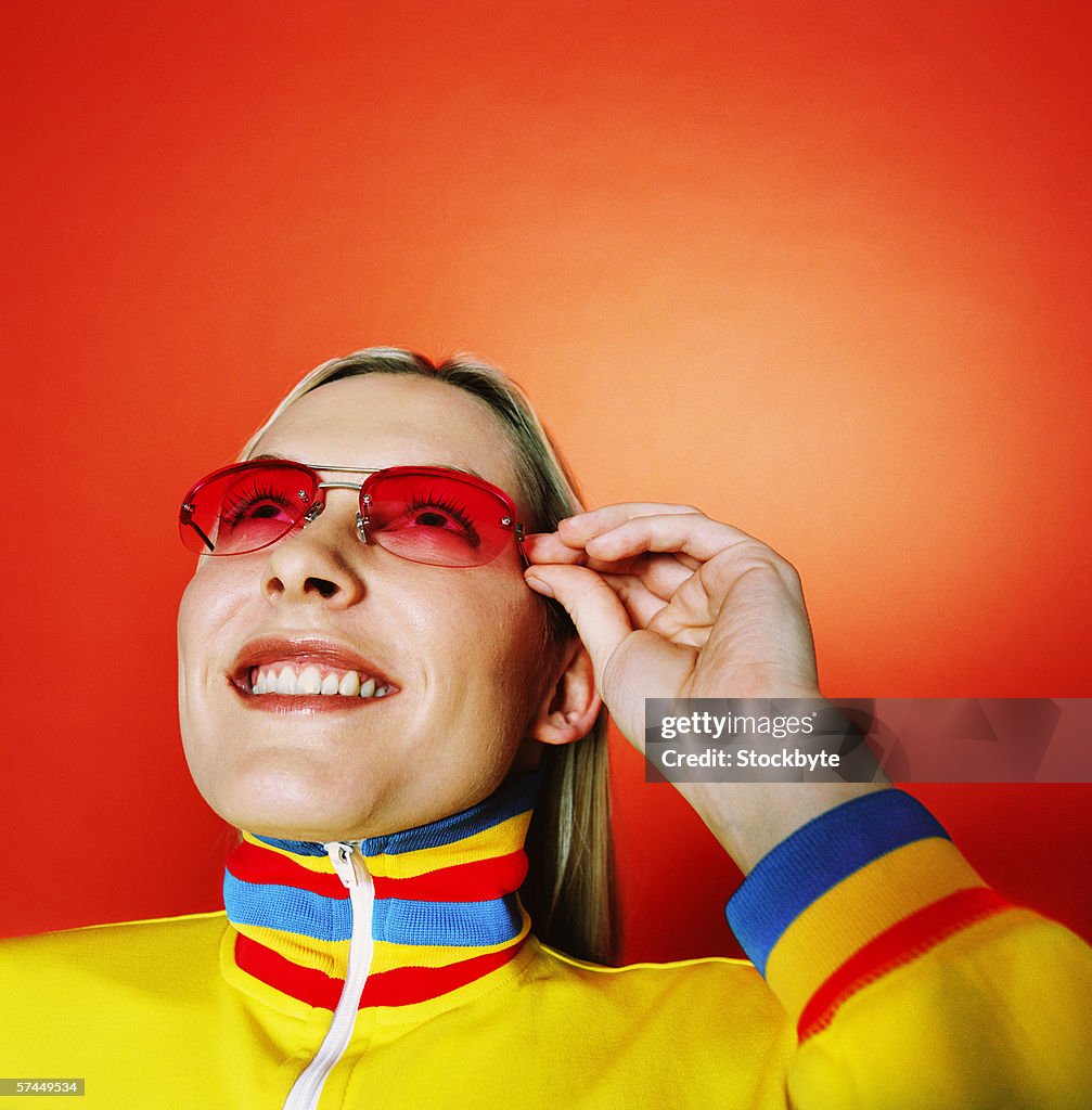 Low Angle View Of A Woman Wearing Sunglasses Looking Up Smiling High