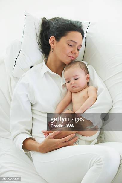 60 Overhead View Smiling Mother And Daughter Hugging On Bed Stock
