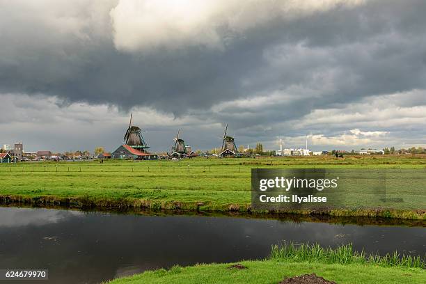 Windmills against a cloudy sky in Zaanse Schans, the Netherlands 이미지 ...