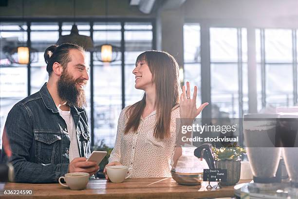 Smiling Couple Holding Hands And Drinking Coffee In Cafe Photos And