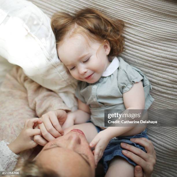 60 Overhead View Smiling Mother And Daughter Hugging On Bed Stock