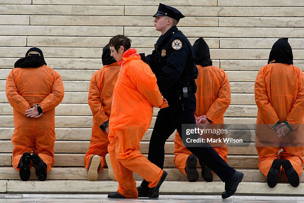 Activists In Orange Jump Suits Get Arrested During A Protest In Front