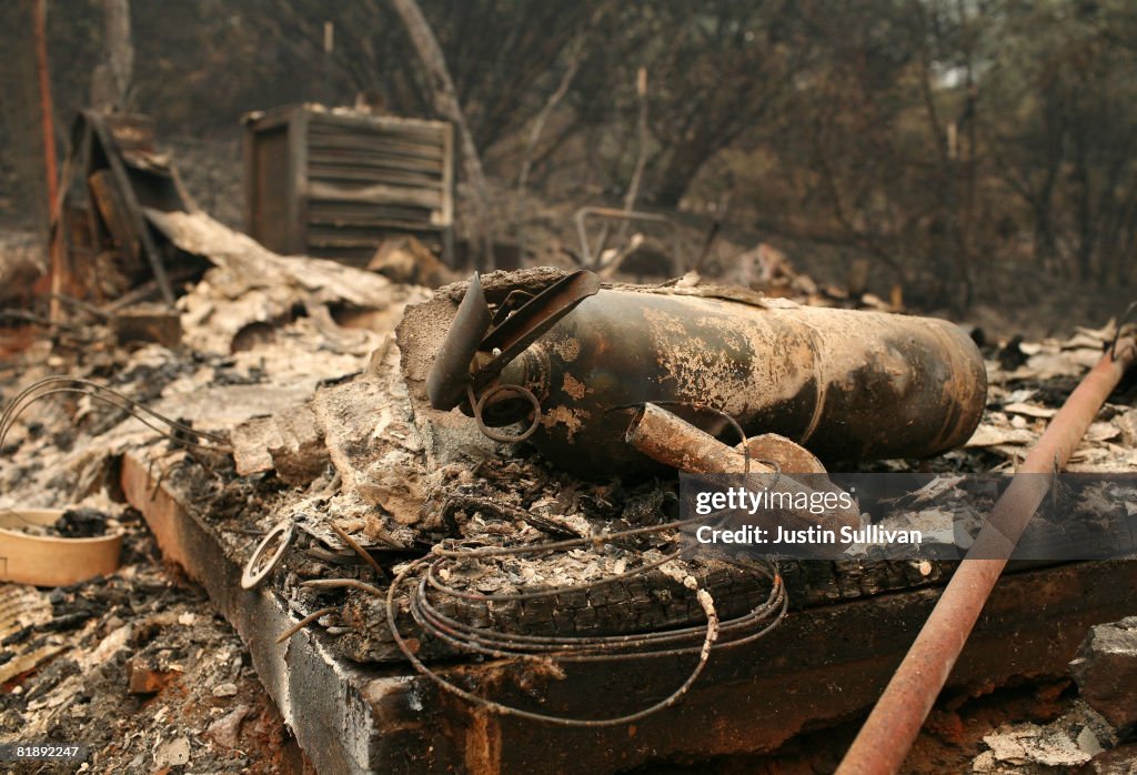 A Charred Fire Extinguisher Sits In The Remains Of A Buned Home July