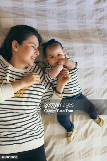 60 Overhead View Smiling Mother And Daughter Hugging On Bed Stock