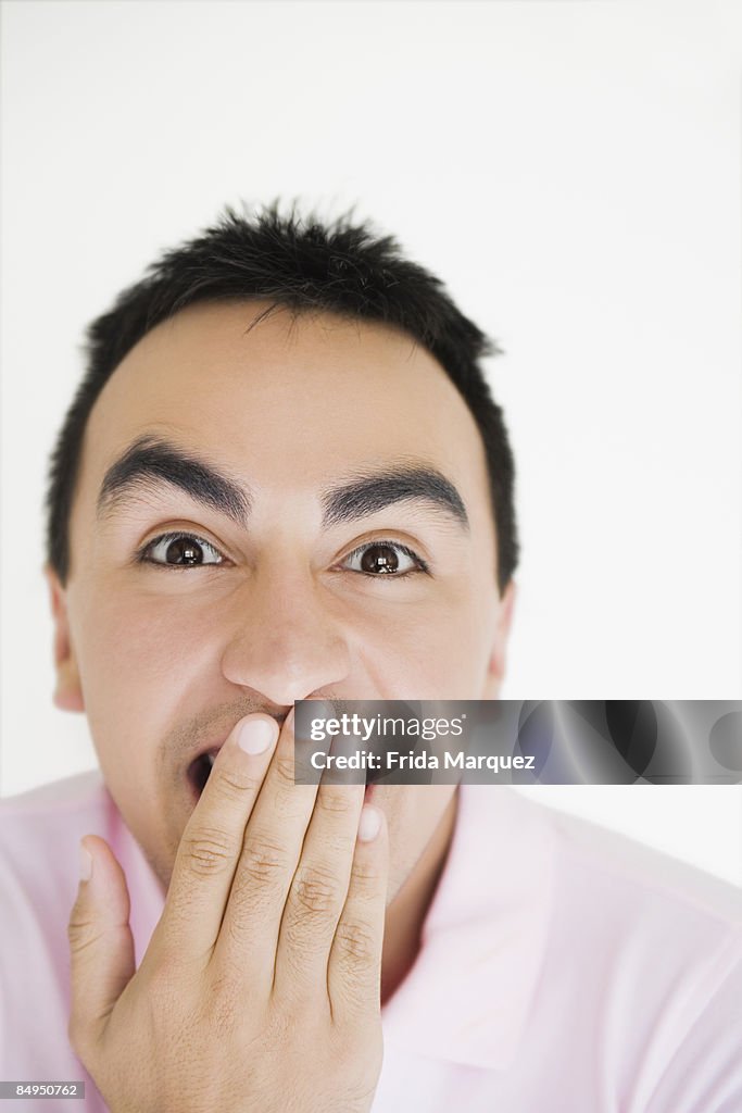 Portrait Of A Young Man Covering His Mouth With His Hand And Smiling