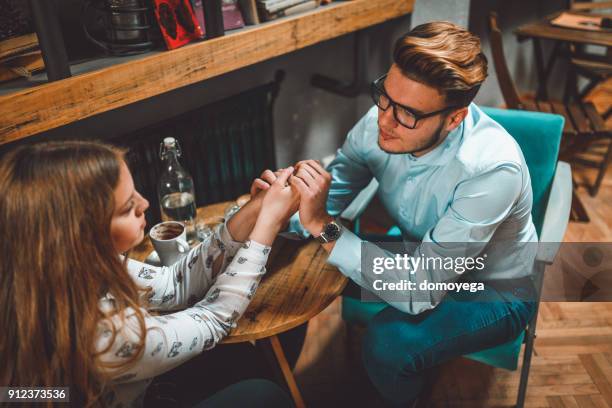 Smiling Couple Holding Hands And Drinking Coffee In Cafe Photos And