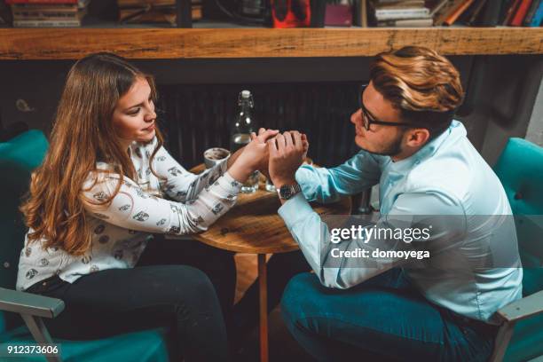 Smiling Couple Holding Hands And Drinking Coffee In Cafe Photos And