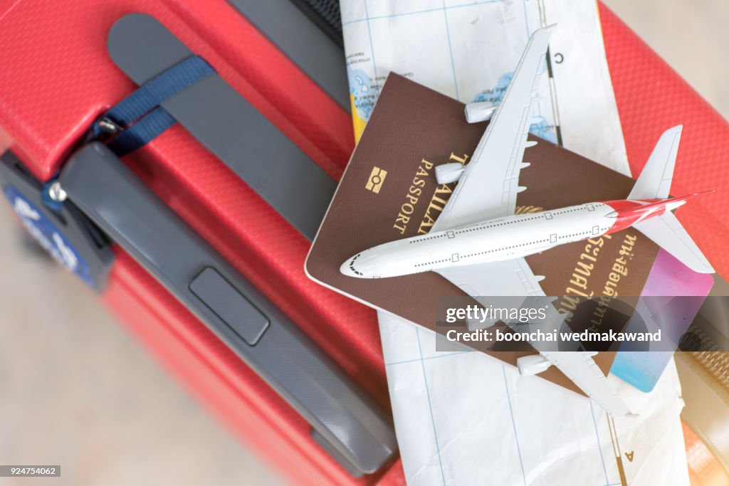 Passport Boarding Pass And Toy Airplane On Luggage Top View High Res