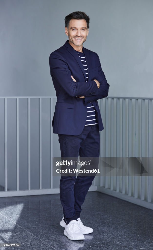 Portrait Of Smiling Businessman With Stubble Wearing Blue Suit High Res