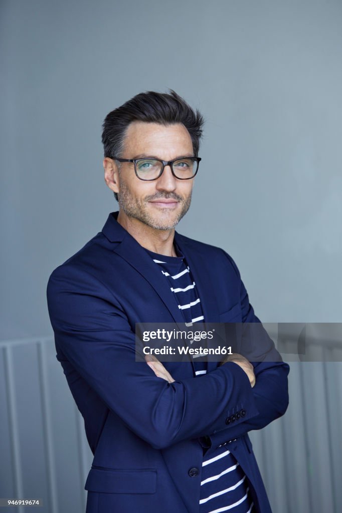 Portrait Of Stylish Businessman With Stubble Wearing Blue Suit And
