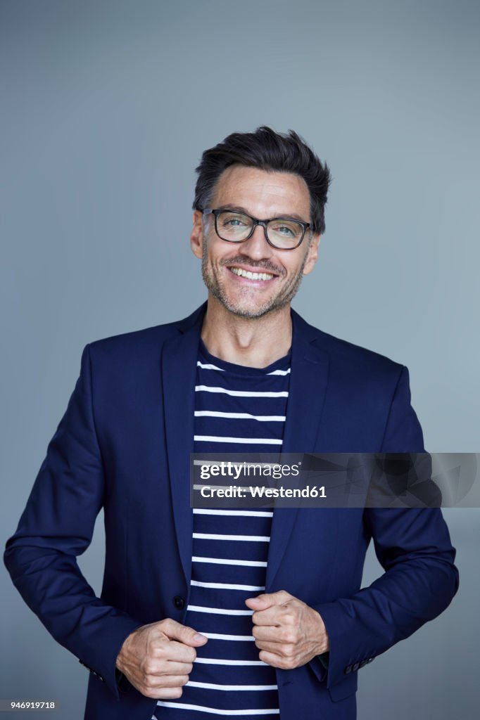 Portrait Of Laughing Businessman With Stubble Wearing Blue Suit Coat