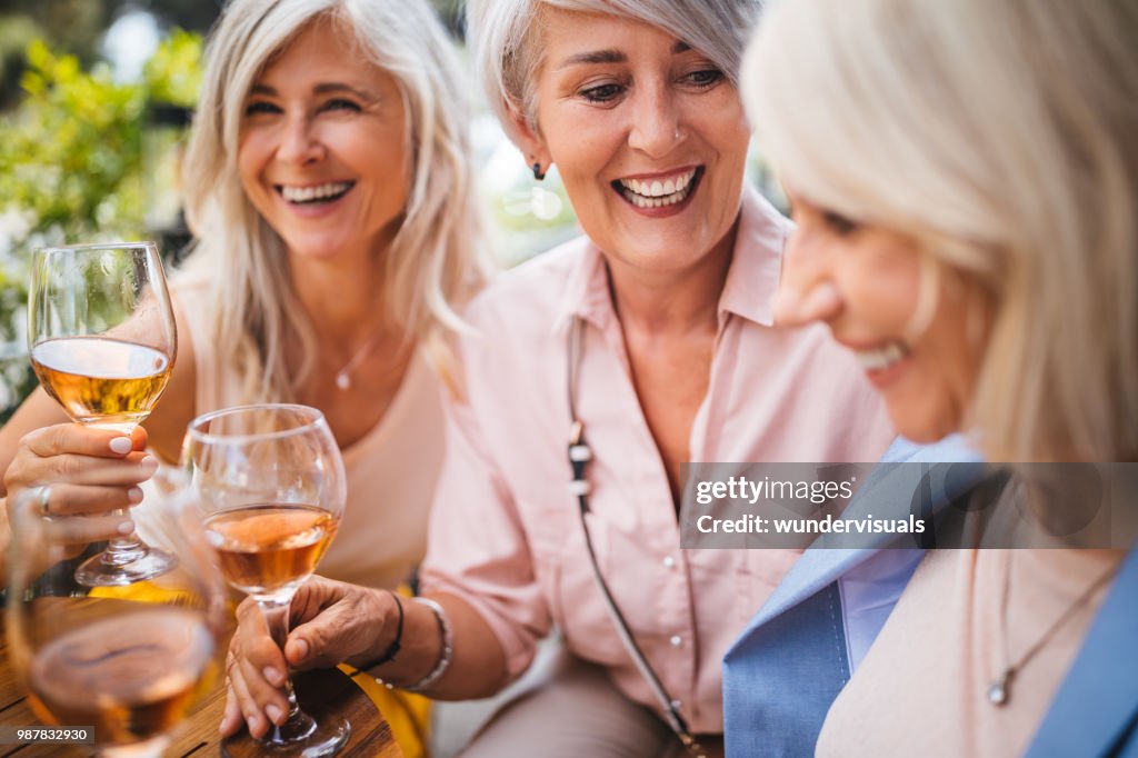 Happy Mature Women Drinking Wine Together In Home Garden High Res Stock