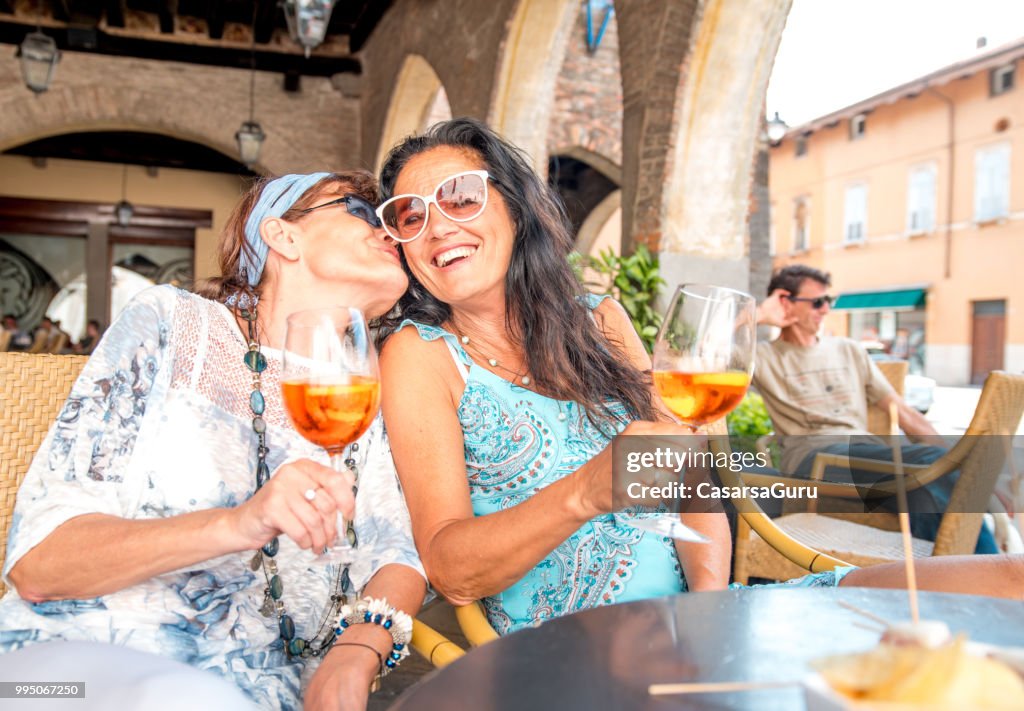 Smiling Couple De Lesbiennes Matures Sembrasser Dans Un Bar Photo