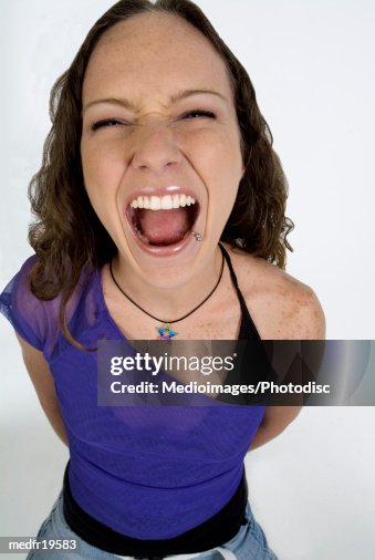 Woman With A Pierced Lip Standing With Her Mouth Open High Res Stock