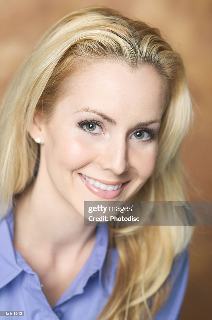 Portrait Of An Attractive Caucasian Blonde Woman In A Blue Shirt As She